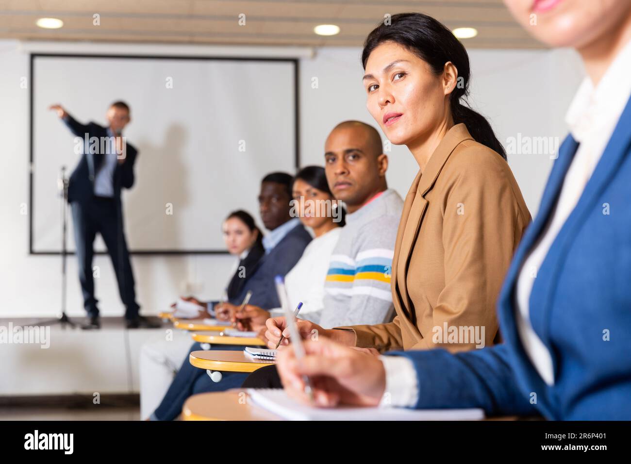 Asian businesswoman sitting at corporate seminar in conference room ...