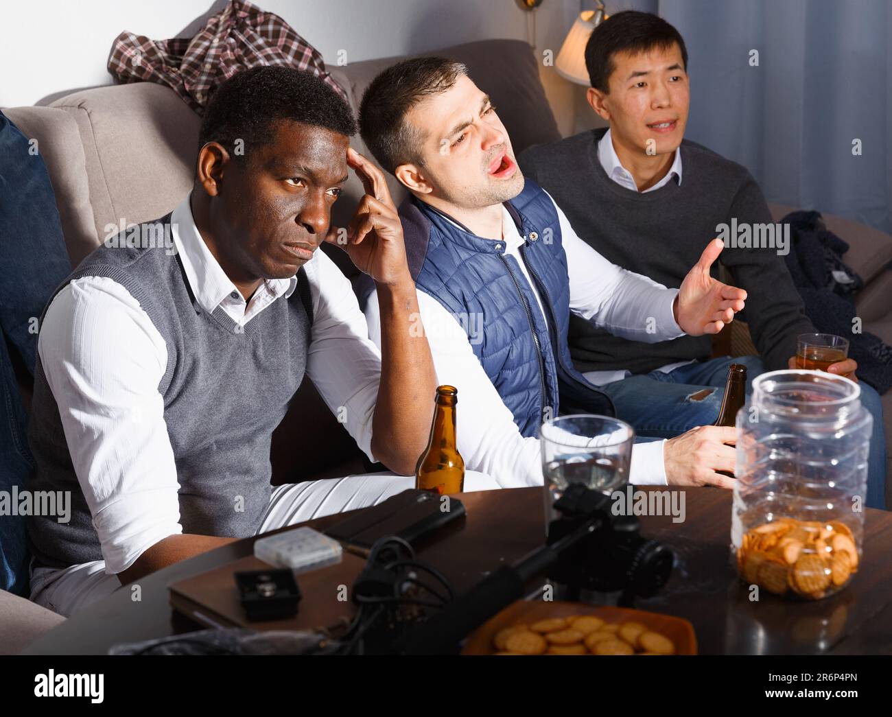 Upset males emotionally watching tv Stock Photo - Alamy