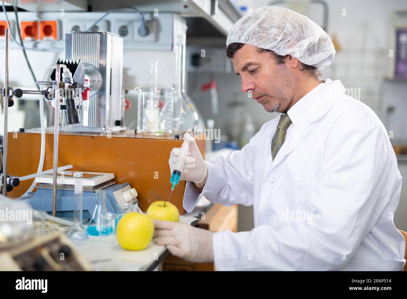 Biochemist performing GMO experiments in modern laboratory, injecting ...