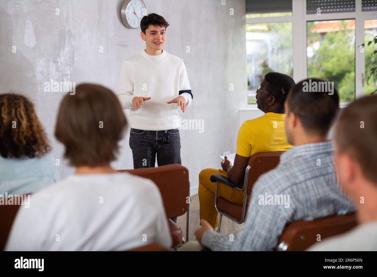 Guy giving lecture to group of men during educational class Stock Photo ...