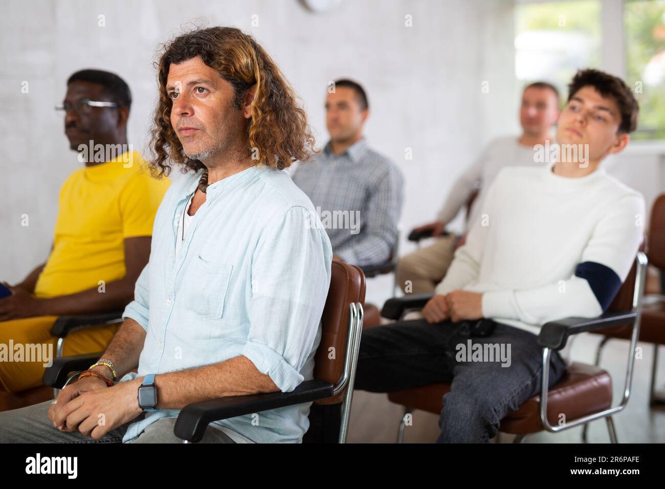 Group of men listening to lecture in auditorium attentively Stock Photo ...