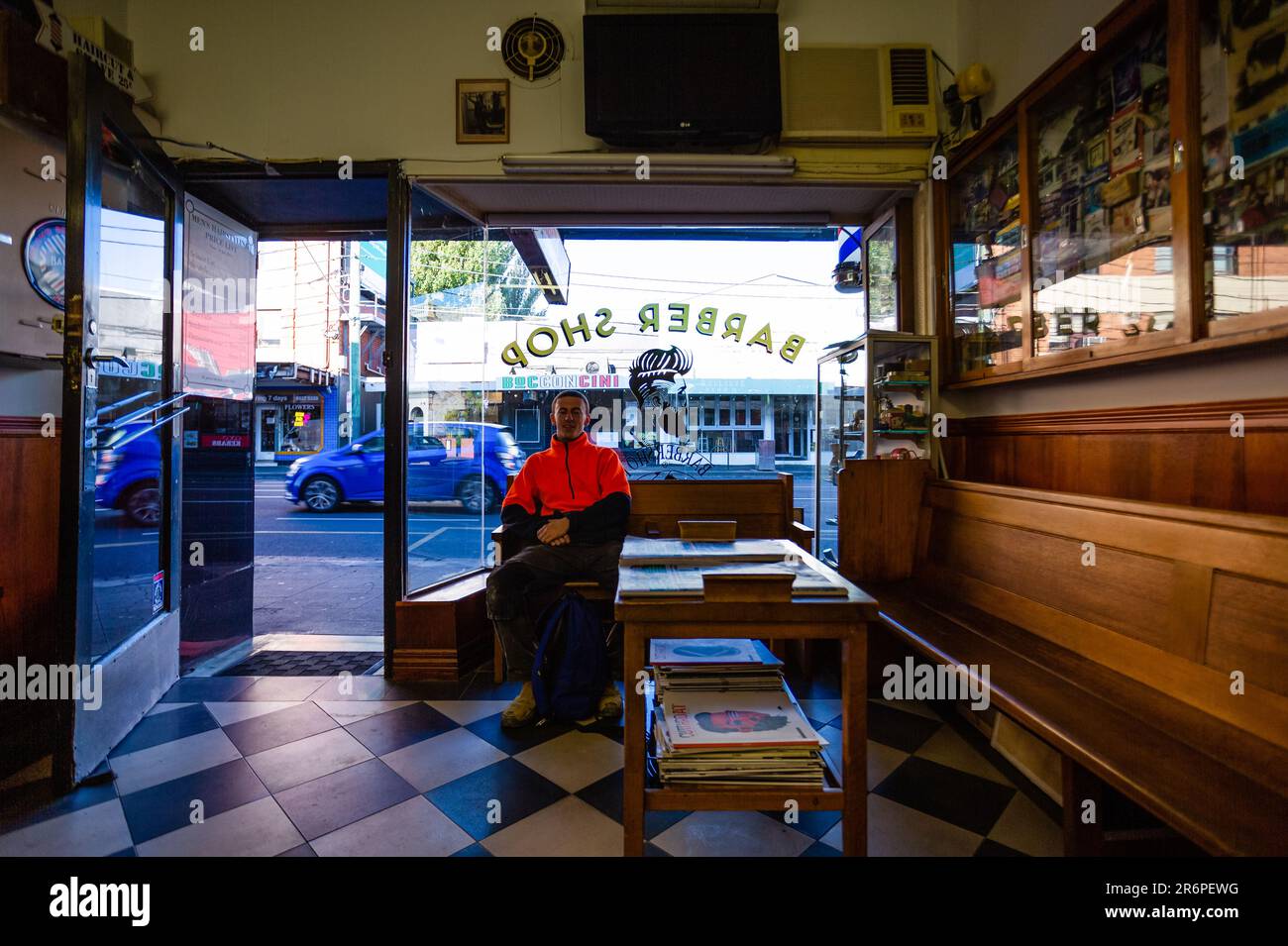A customer waits for a hair cut at The Kilda Barber Shop amid COVID 19 ...