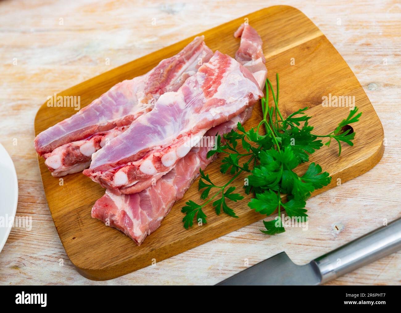 Fresh meaty pork ribs with condiments ready for cooking on wooden ...