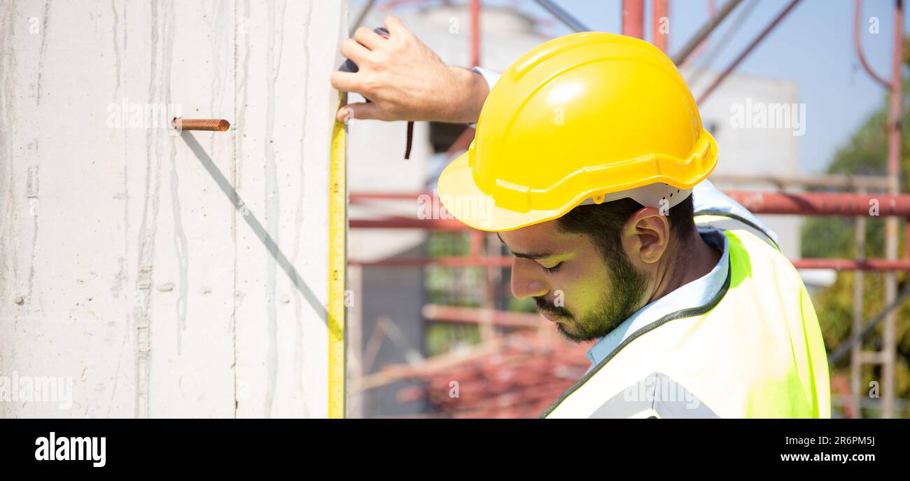 Engineer young man using tape measure for check and examining length of ...