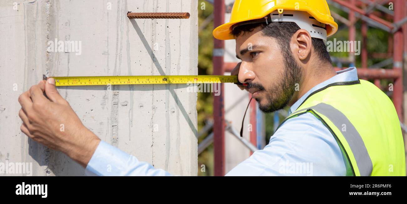 Engineer young man using tape measure for check and examining length of structure with ...