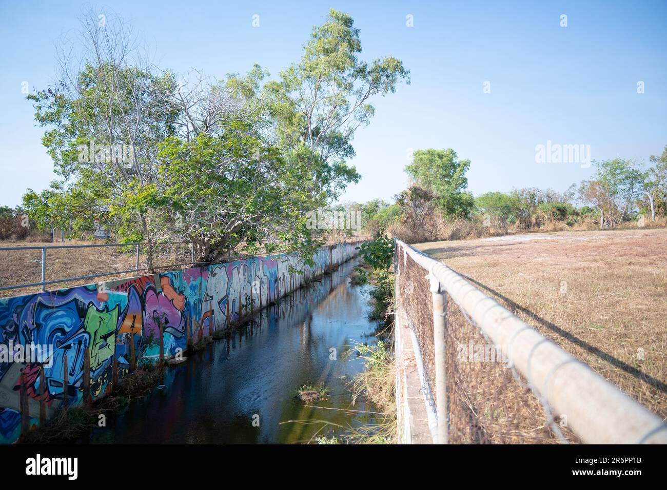 A graffiti lined concrete water channel in Darwin city stretching into ...
