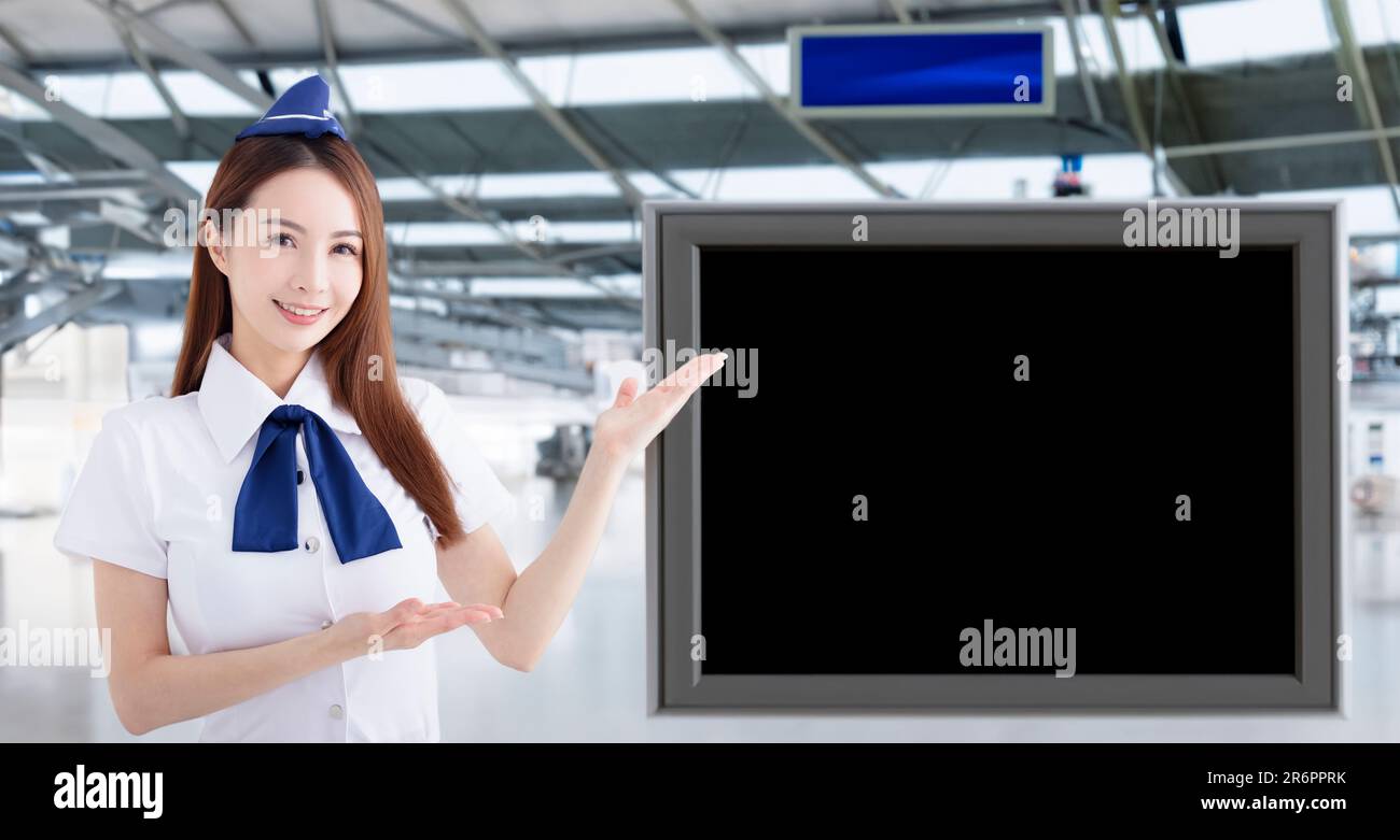 Beautiful Airline stewardess showing the blank TV screen in airport ...