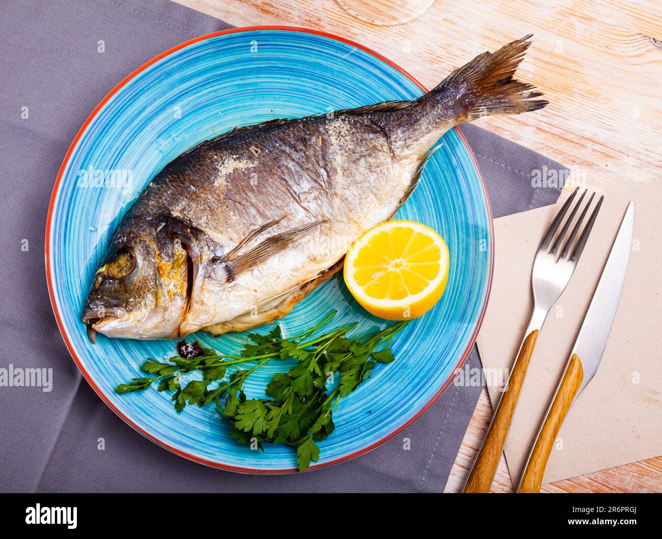 Baked dorado fish with orange and parsley Stock Photo - Alamy