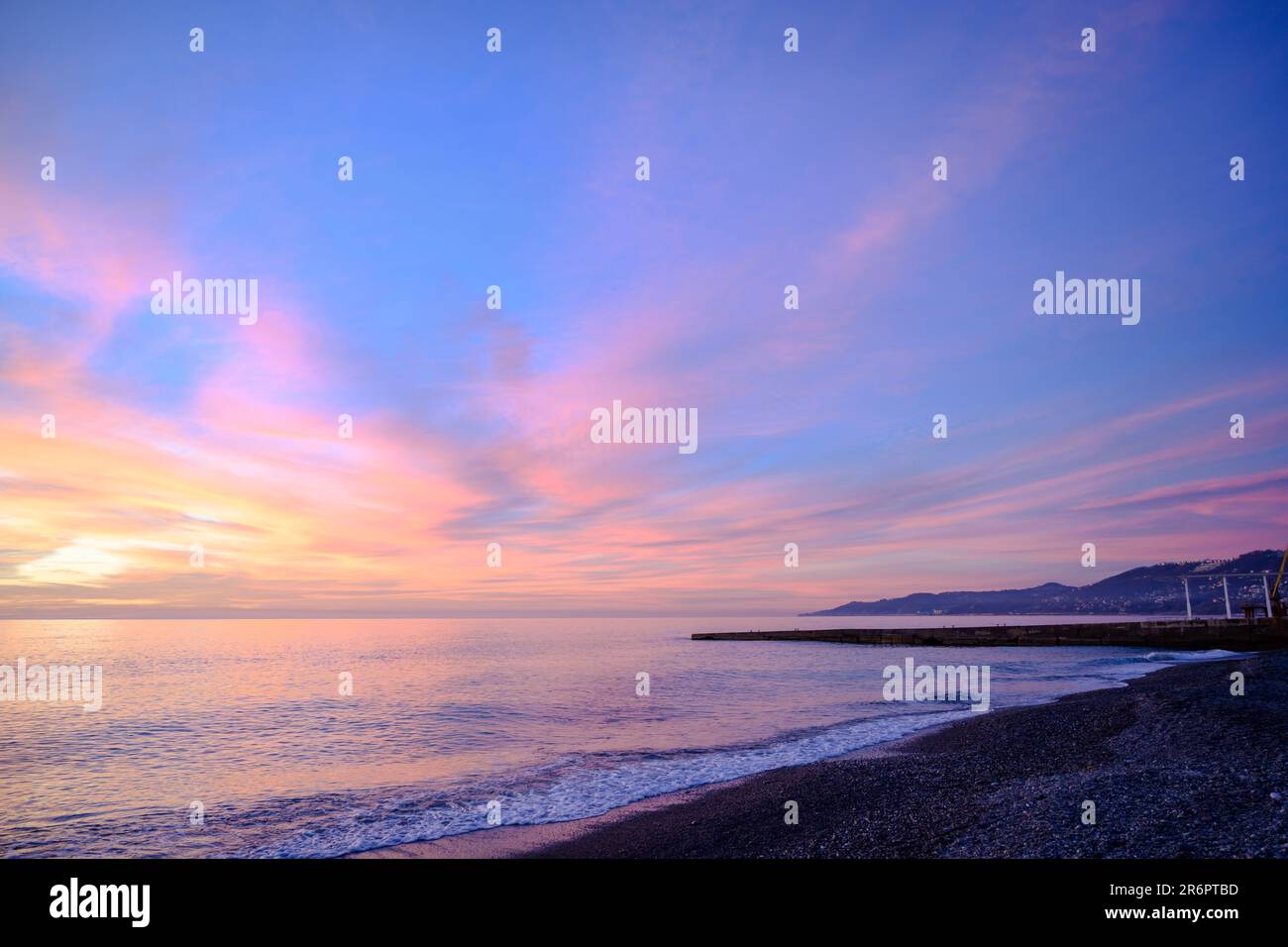 Colorful sunset over the sea with a port city on the horizon Stock ...