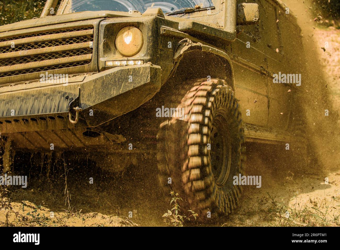 Offroad vehicle coming out of a mud hole hazard. Bottom view to big ...