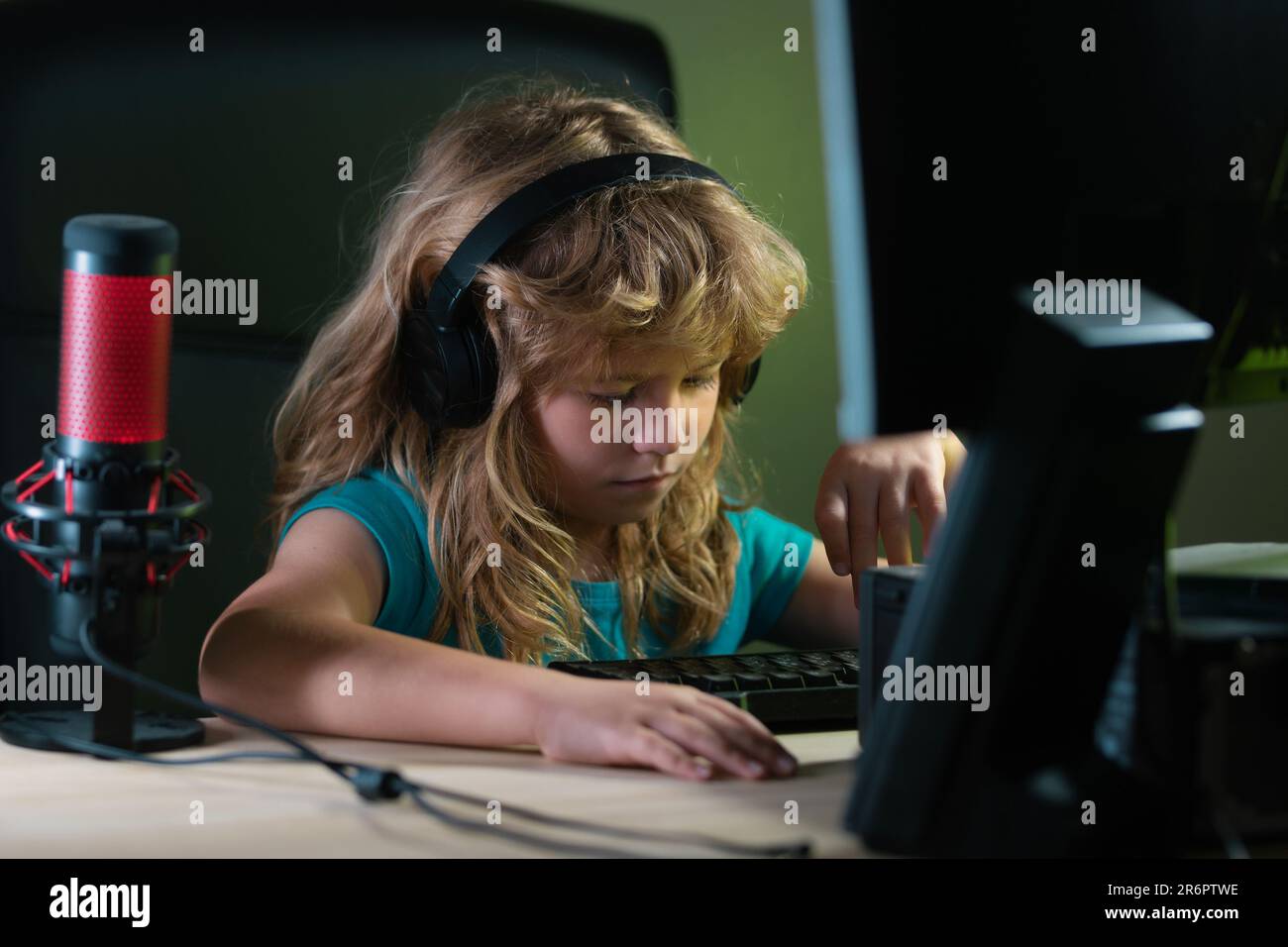 Little child gamer play computer game on desktop. Gaming stream and ...