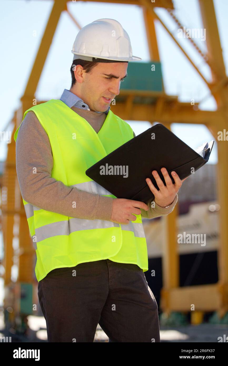 Documents, construction site and man for inspection, reading building information or compliance ...
