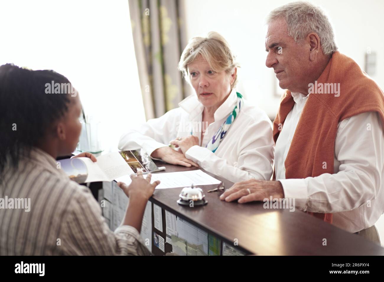 Reception, hotel and senior couple on vacation or elderly person at ...