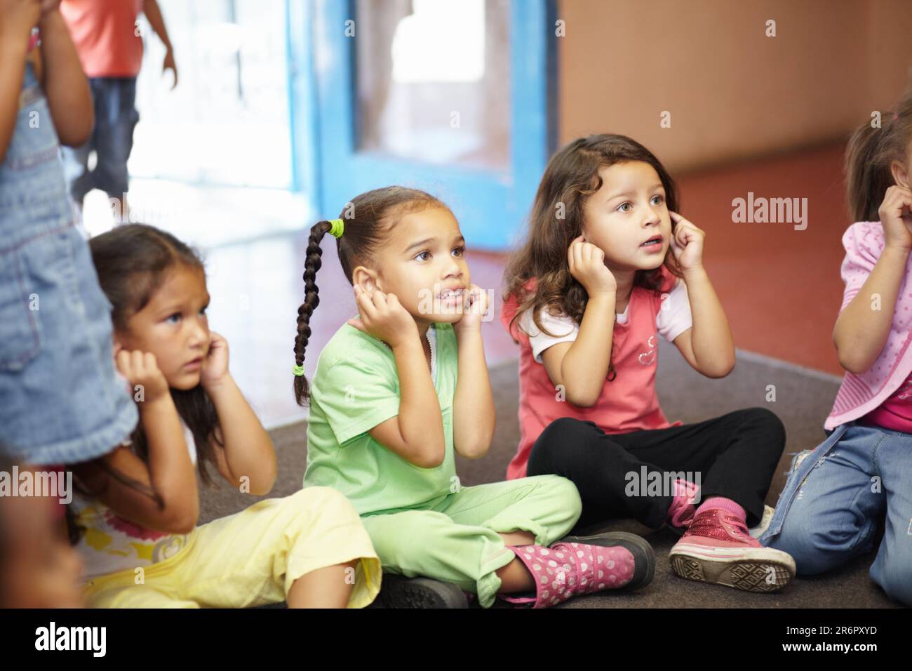 School children on floor listening to teacher for anatomy education ...