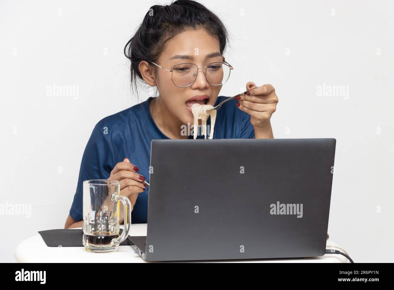 Asian businesswoman eating at computer hi-res stock photography and ...