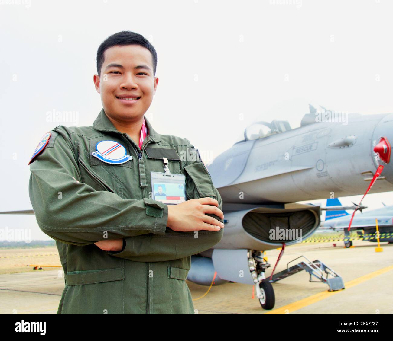 Portrait of asian man, fighter pilot with jet and confident smile at ...