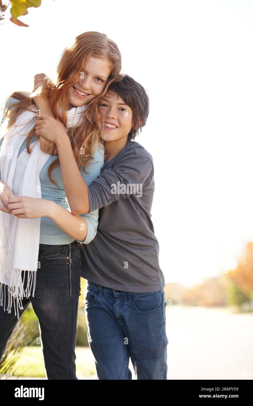 Love, portrait of brother with sister and hug outdoors for support with ...
