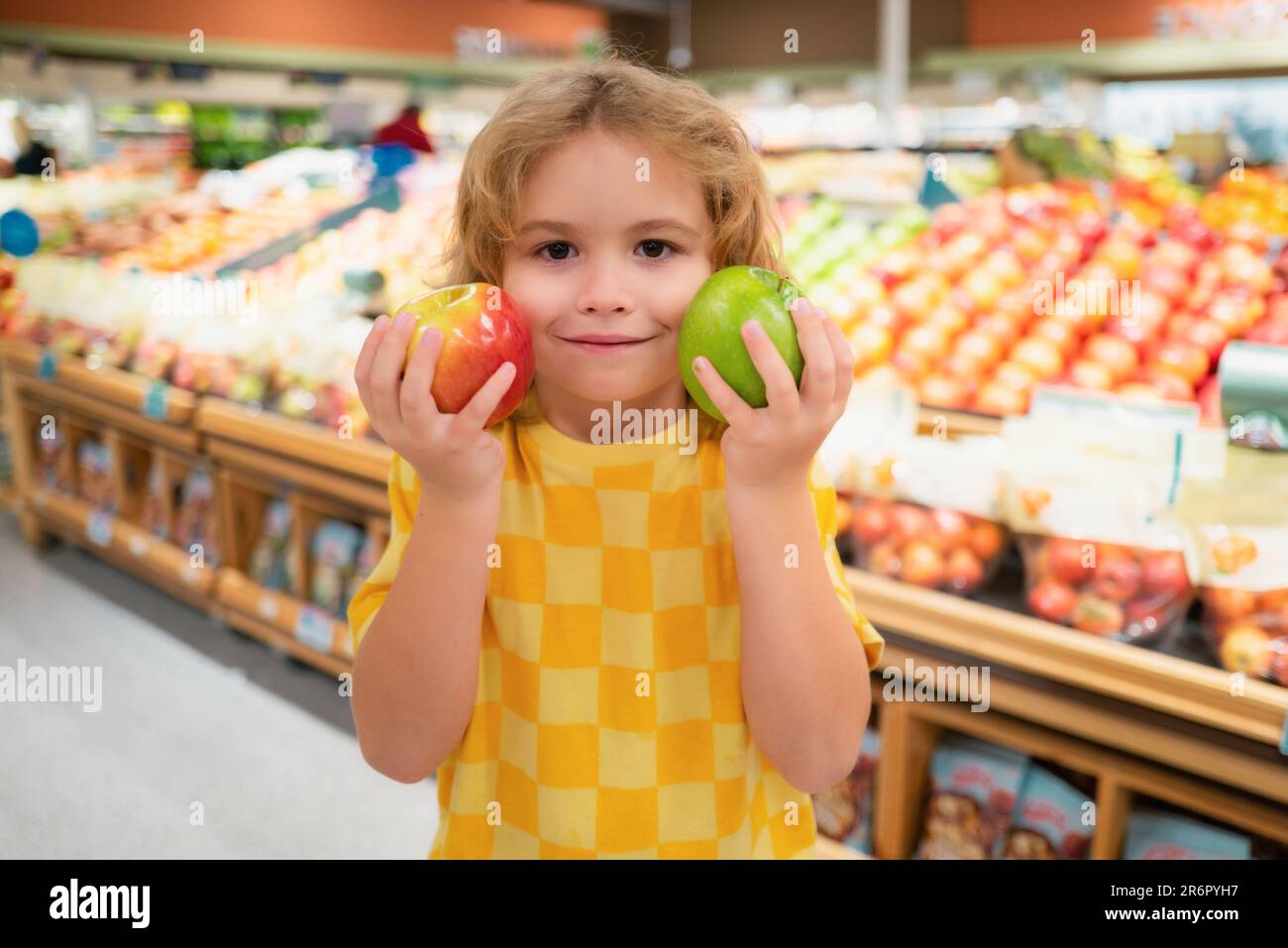 Child hold apple fruits at grocery store. Kid choosing fruits and ...