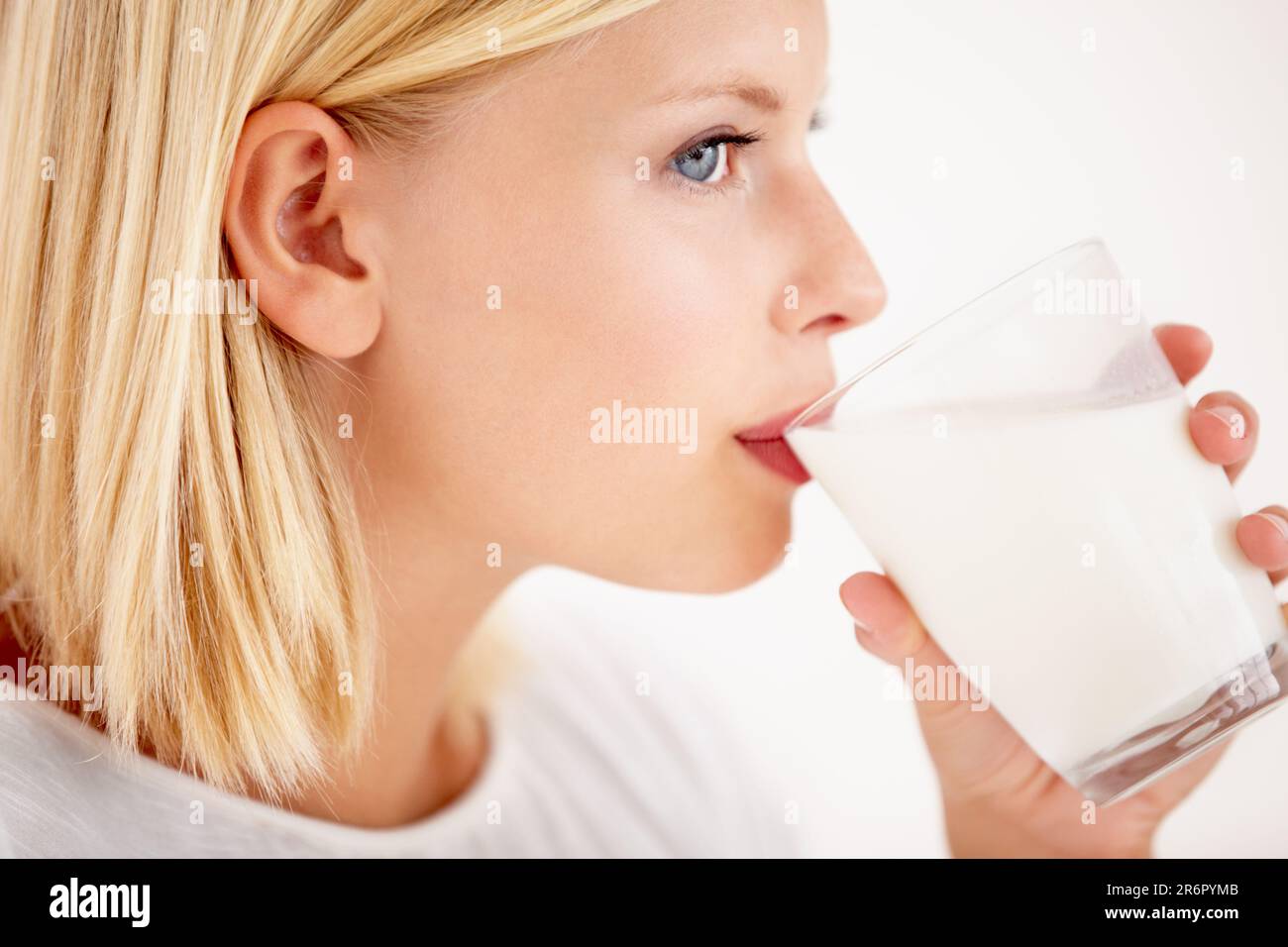 Face, milk and thinking with a woman drinking from a glass in studio ...