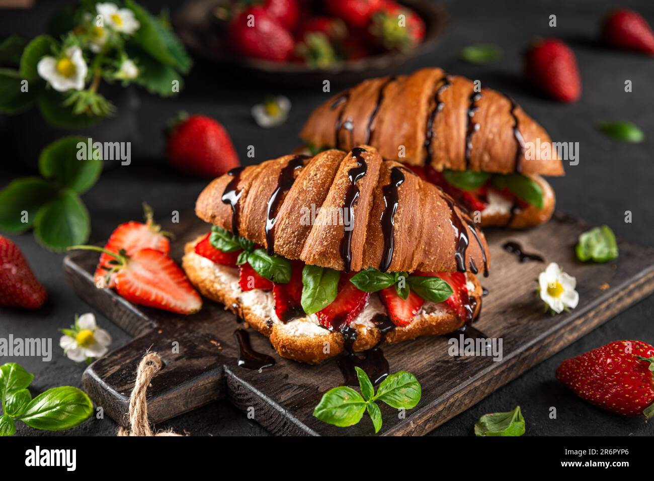 Tasty breakfast. Croissants with strawberries, cream cheese, basil and ...