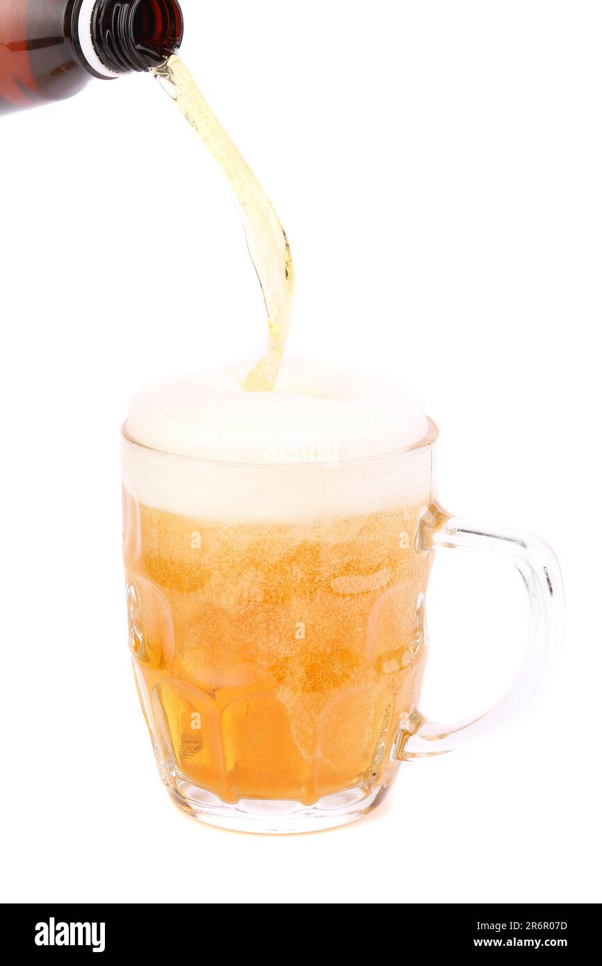 Pouring beer into mug isolated over a white background Stock Photo - Alamy