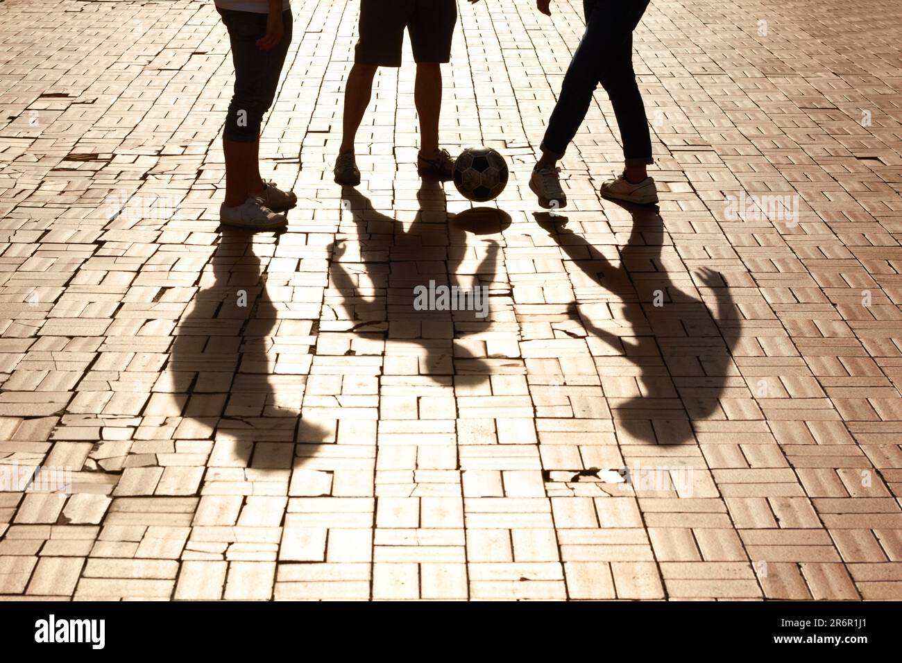 Sports, football and shadow of friends with a ball training for a skill ...