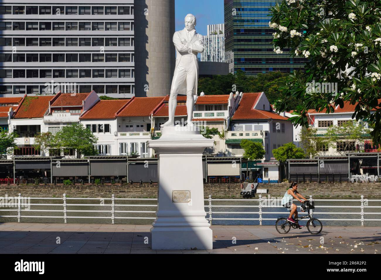 A woman cycles past a statue of Sir Stamford Raffles at Raffles' Landing Site by the Singapore ...
