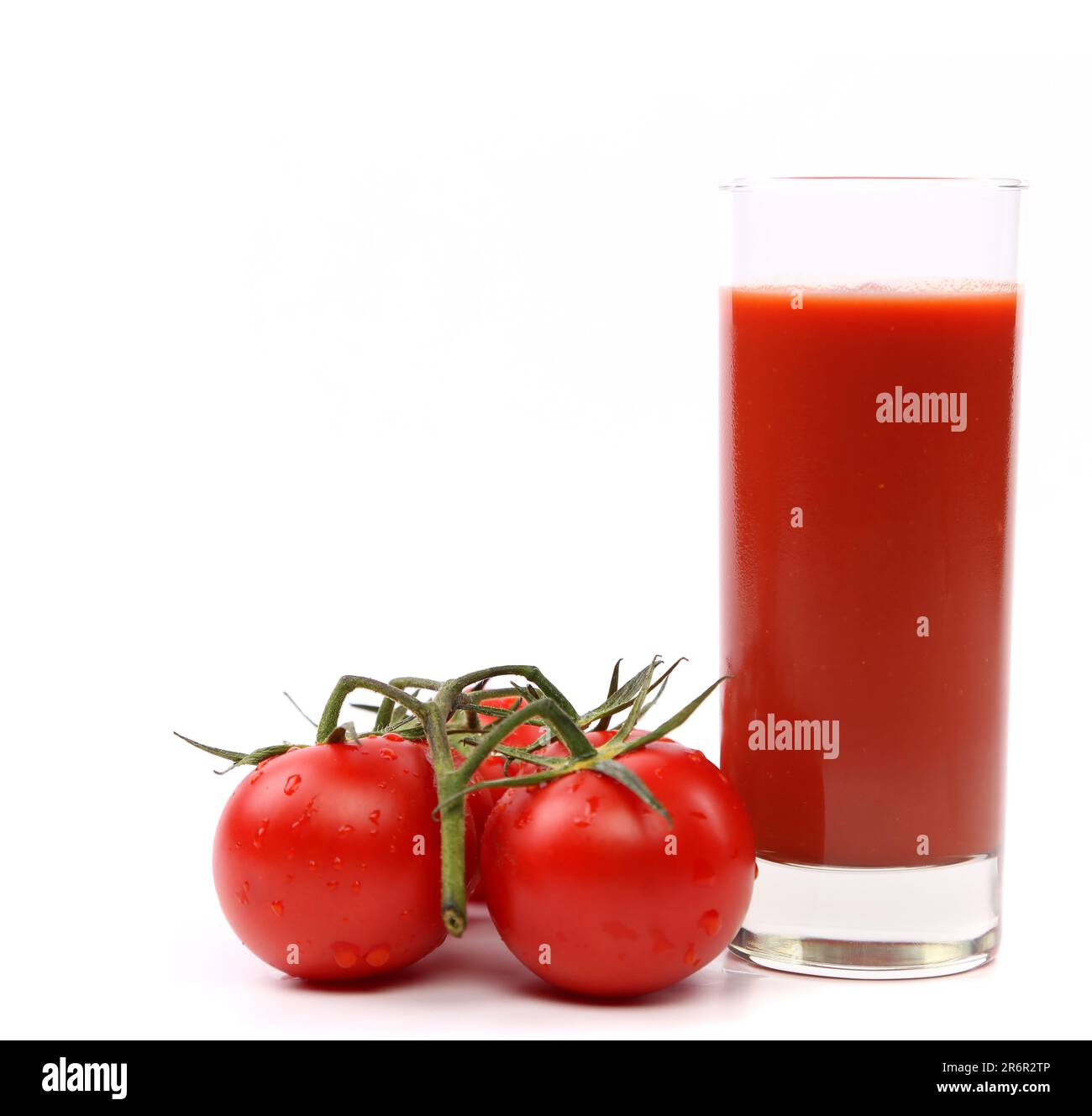 Tomato juice in glass with a cluster of small tomatoes isolated on ...