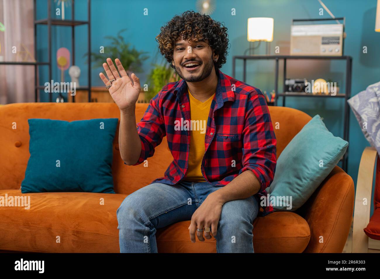 Hello. Indian handsome man smiling friendly at camera and waving hands ...