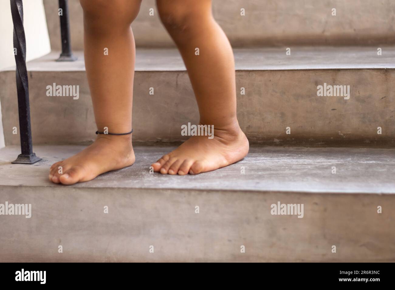 Feet of a one year old baby standing on the stair Stock Photo - Alamy