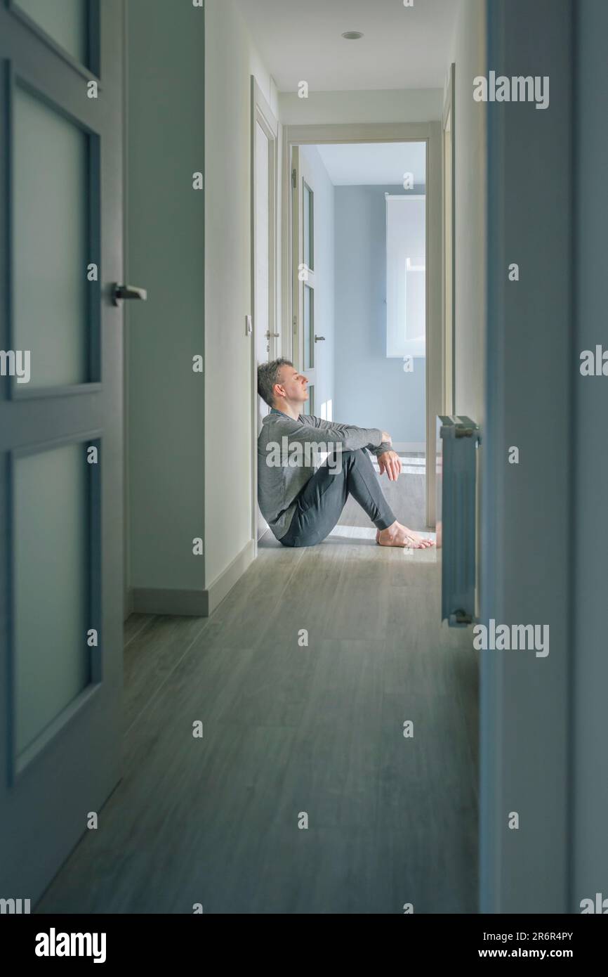 Man with mental disorder sitting on the floor Stock Photo - Alamy