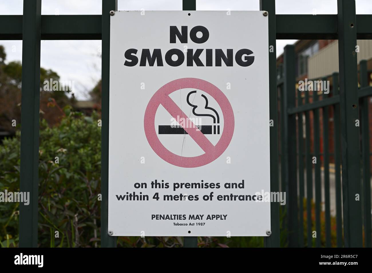 Scratched, faded, and weathered No Smoking sign, red and white with ...