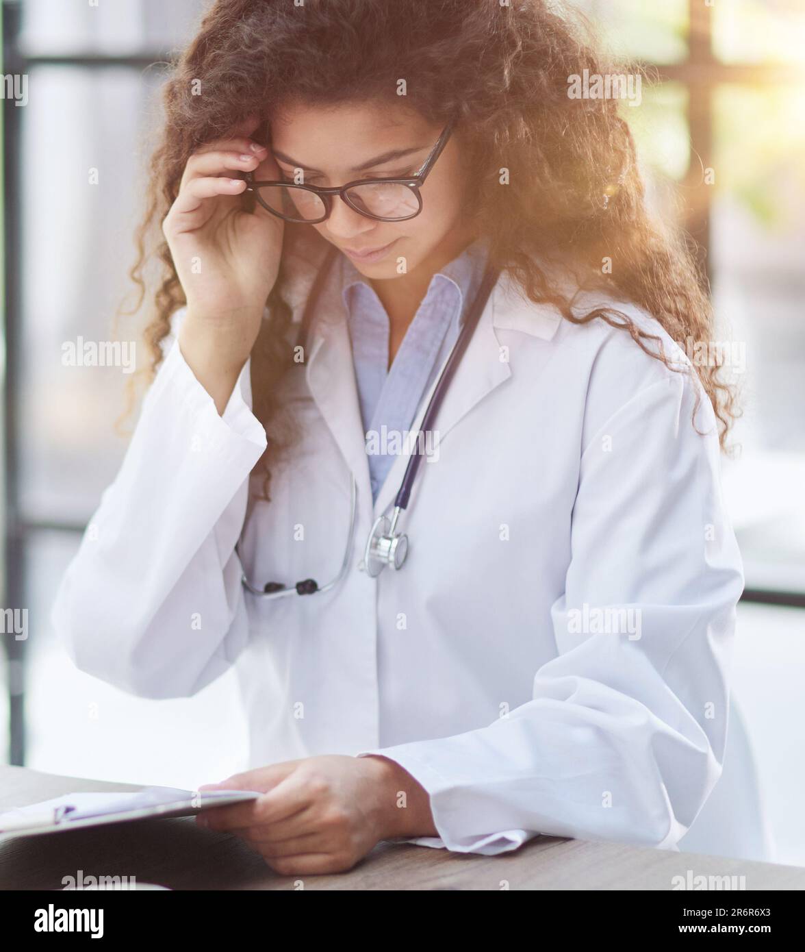 Attractive young female doctor reads checklist from clipboard Stock ...