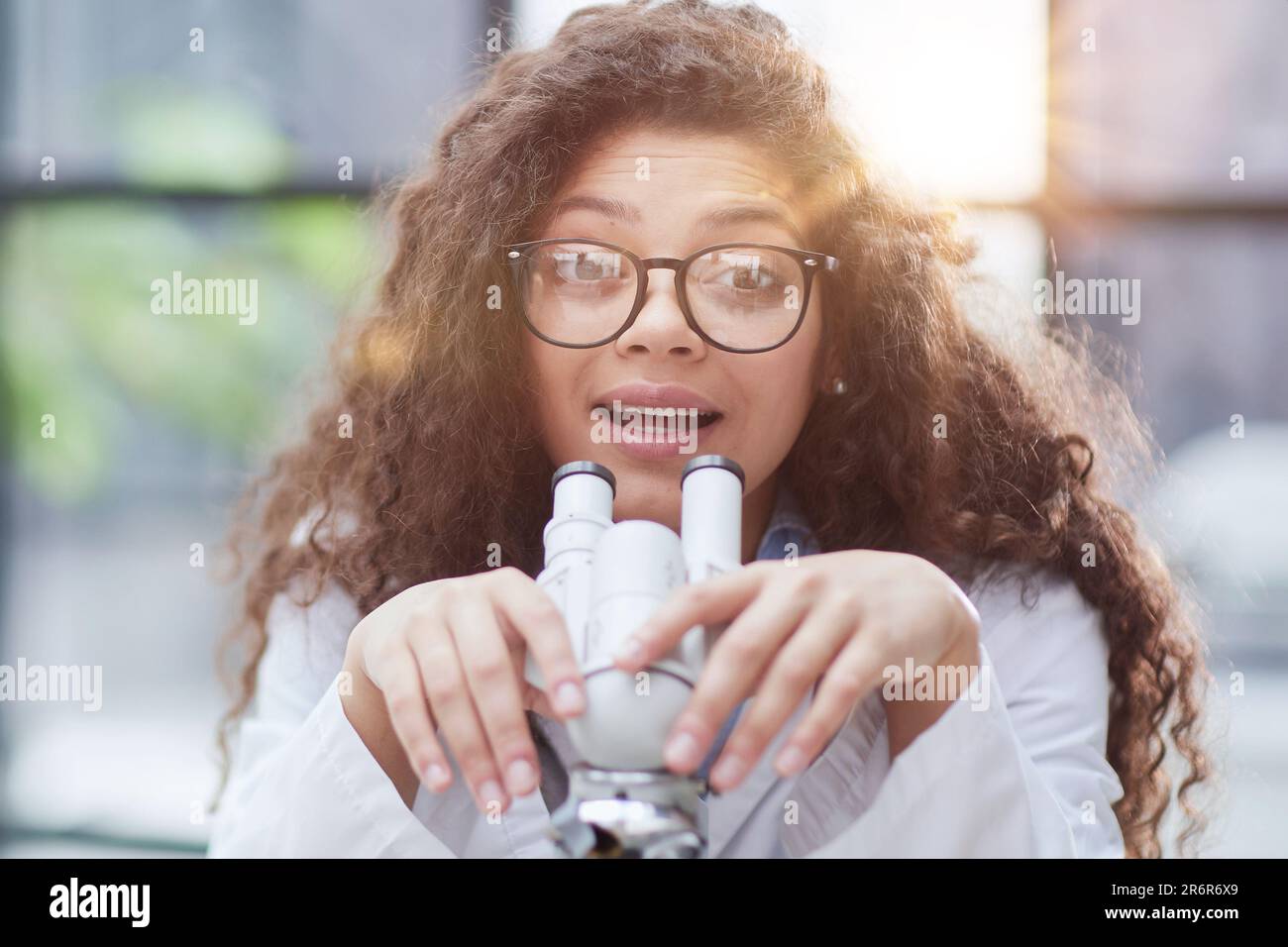 Attractive female scientist looking through a microscope Stock Photo ...