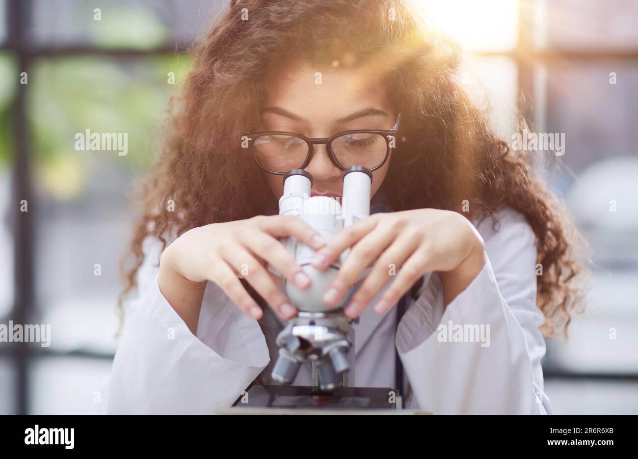 Attractive female scientist looking through a microscope Stock Photo ...