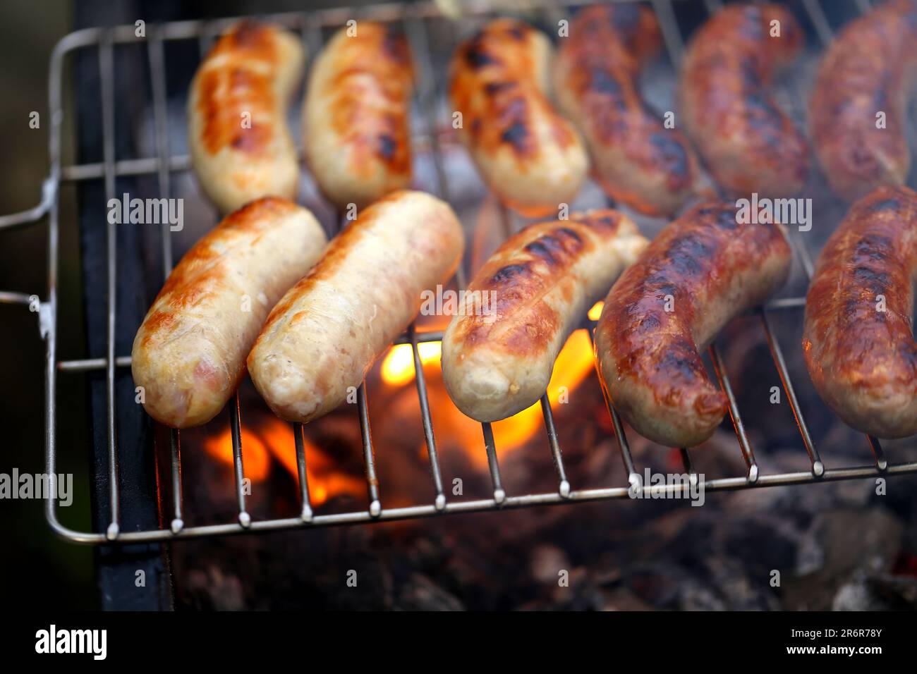 Sausages on grill on a whole background Stock Photo - Alamy