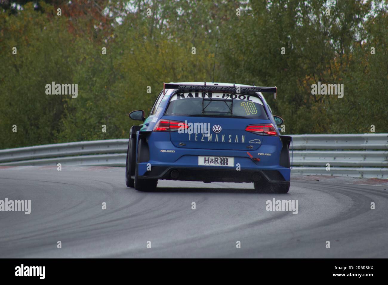 A blue race car driving on a track, perfect for any motorsport or ...