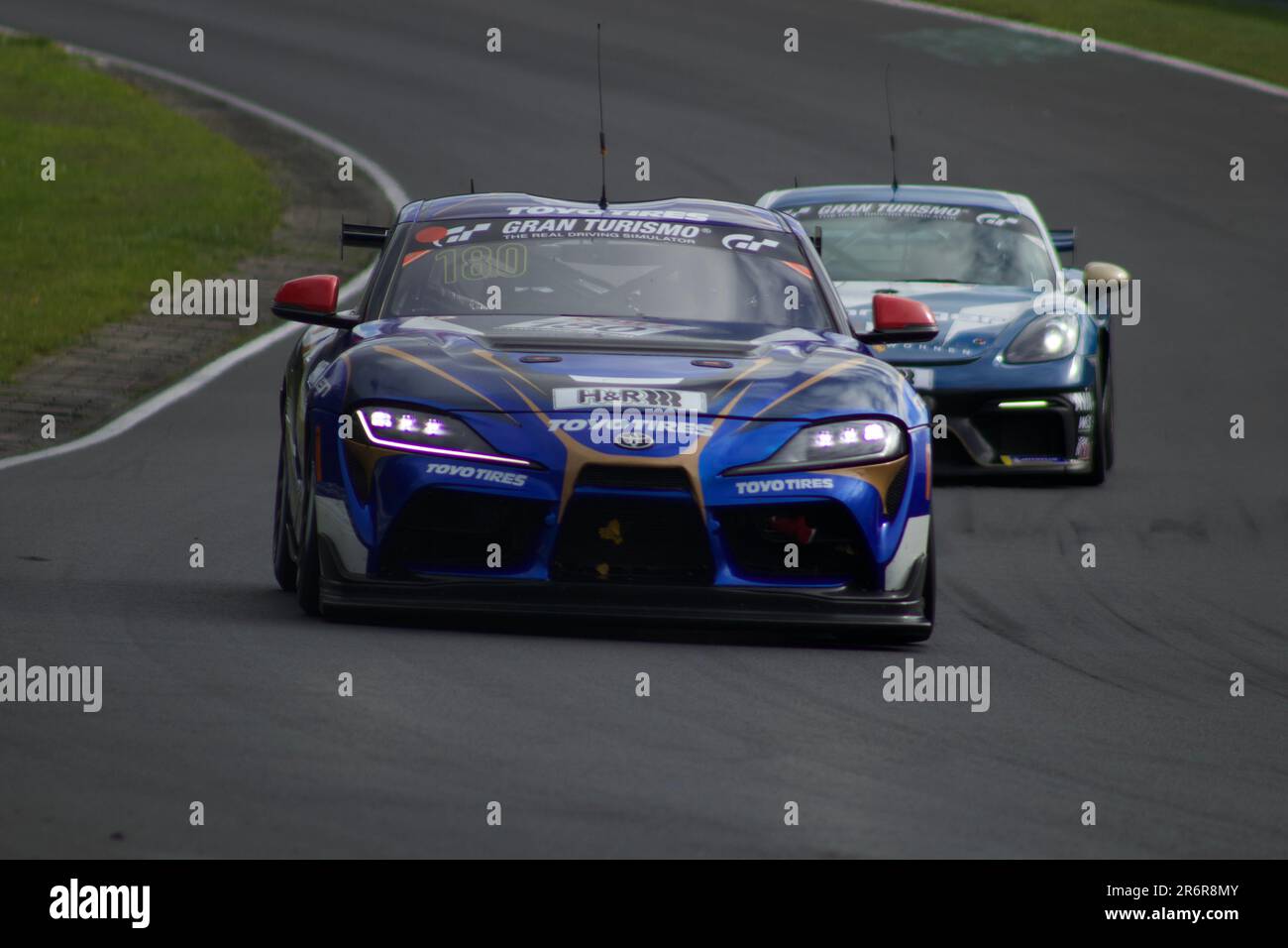 A blue race car driving on a track, perfect for any motorsport or ...