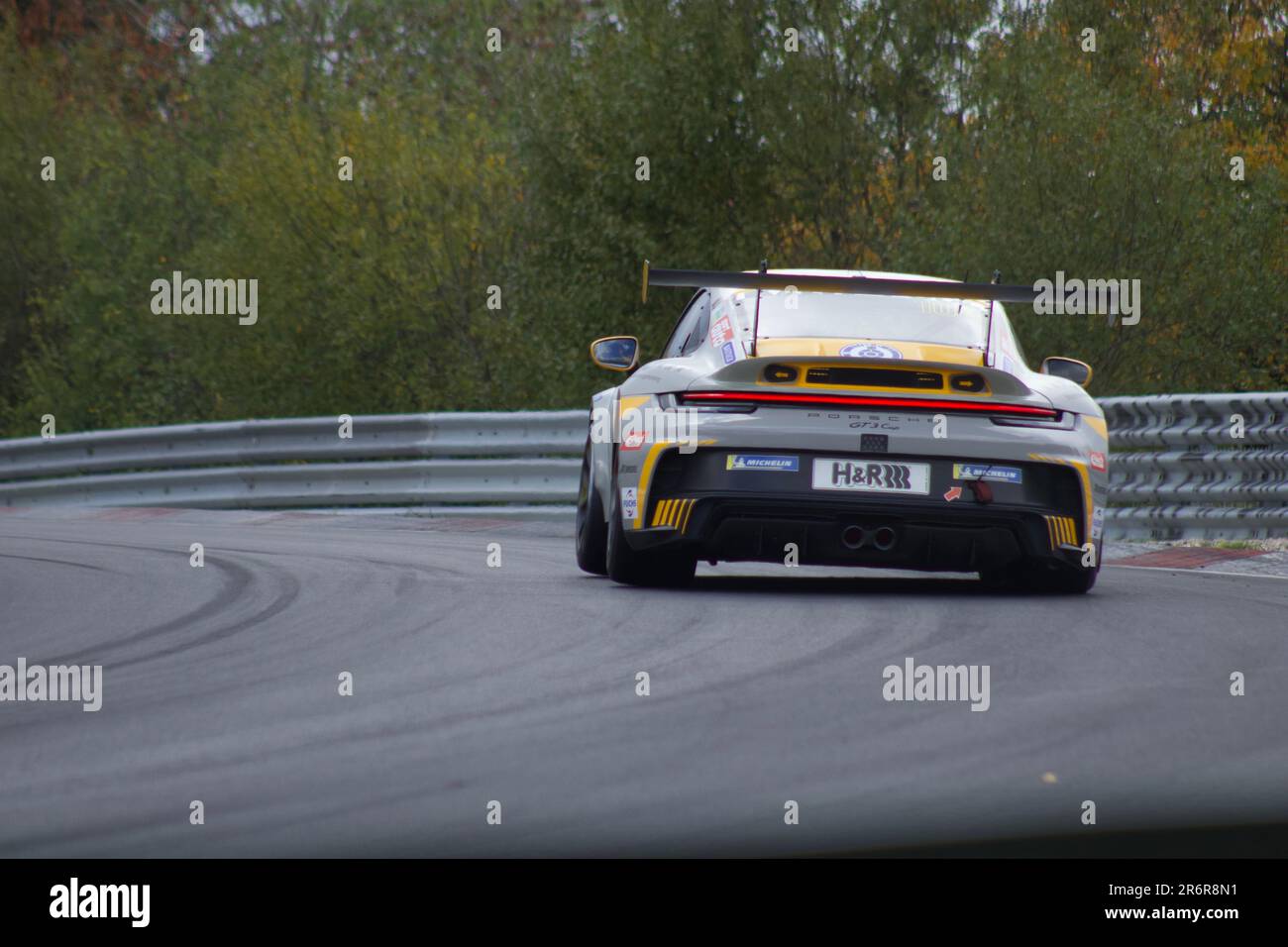 A grey race car driving on a track, perfect for any motorsport or ...