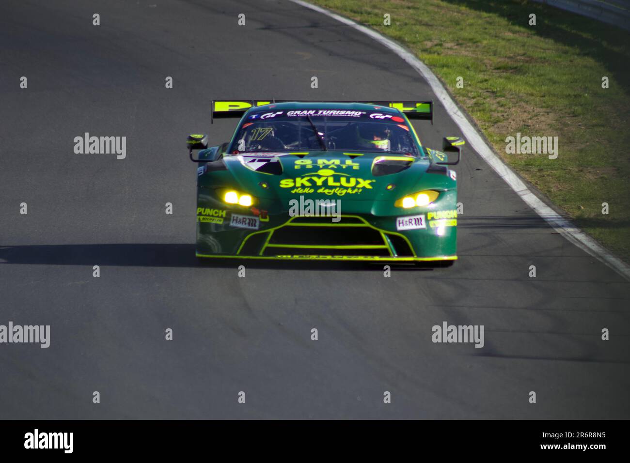A green race car driving on a track, perfect for any motorsport or ...