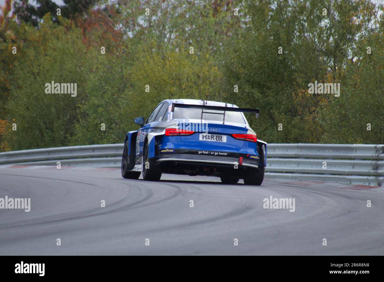 A blue race car driving on a track, perfect for any motorsport or ...