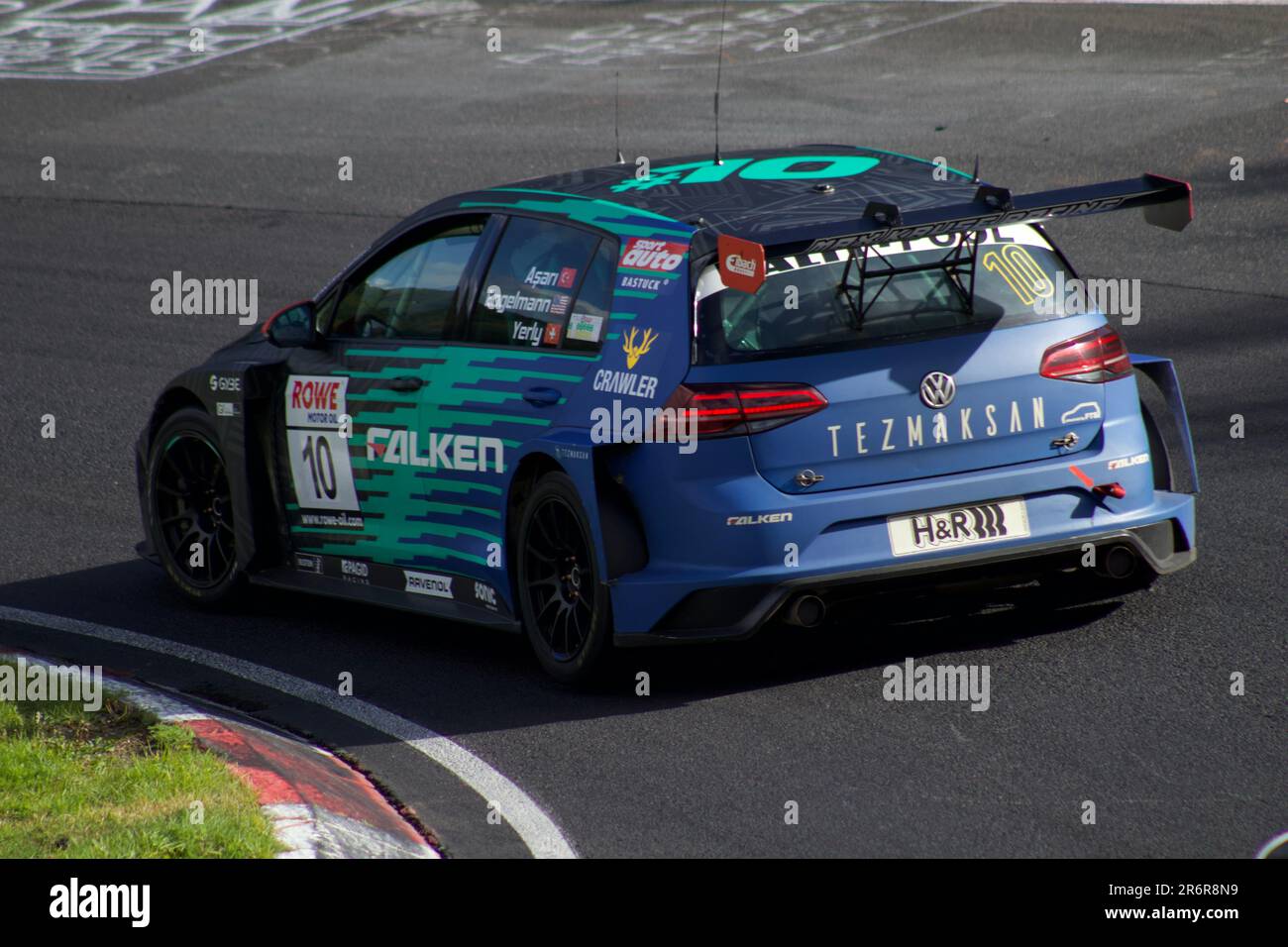A blue and green race car driving on a track, perfect for any ...