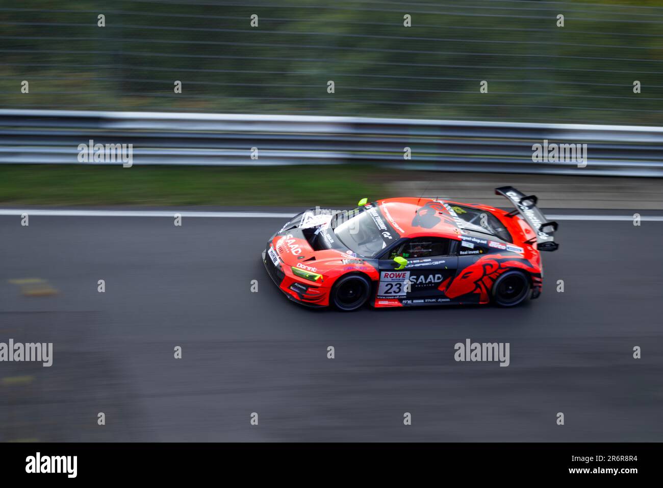 An orange race car driving on a track, perfect for any motorsport or ...