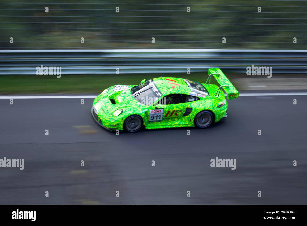 A green race car driving on a track, perfect for any motorsport or ...