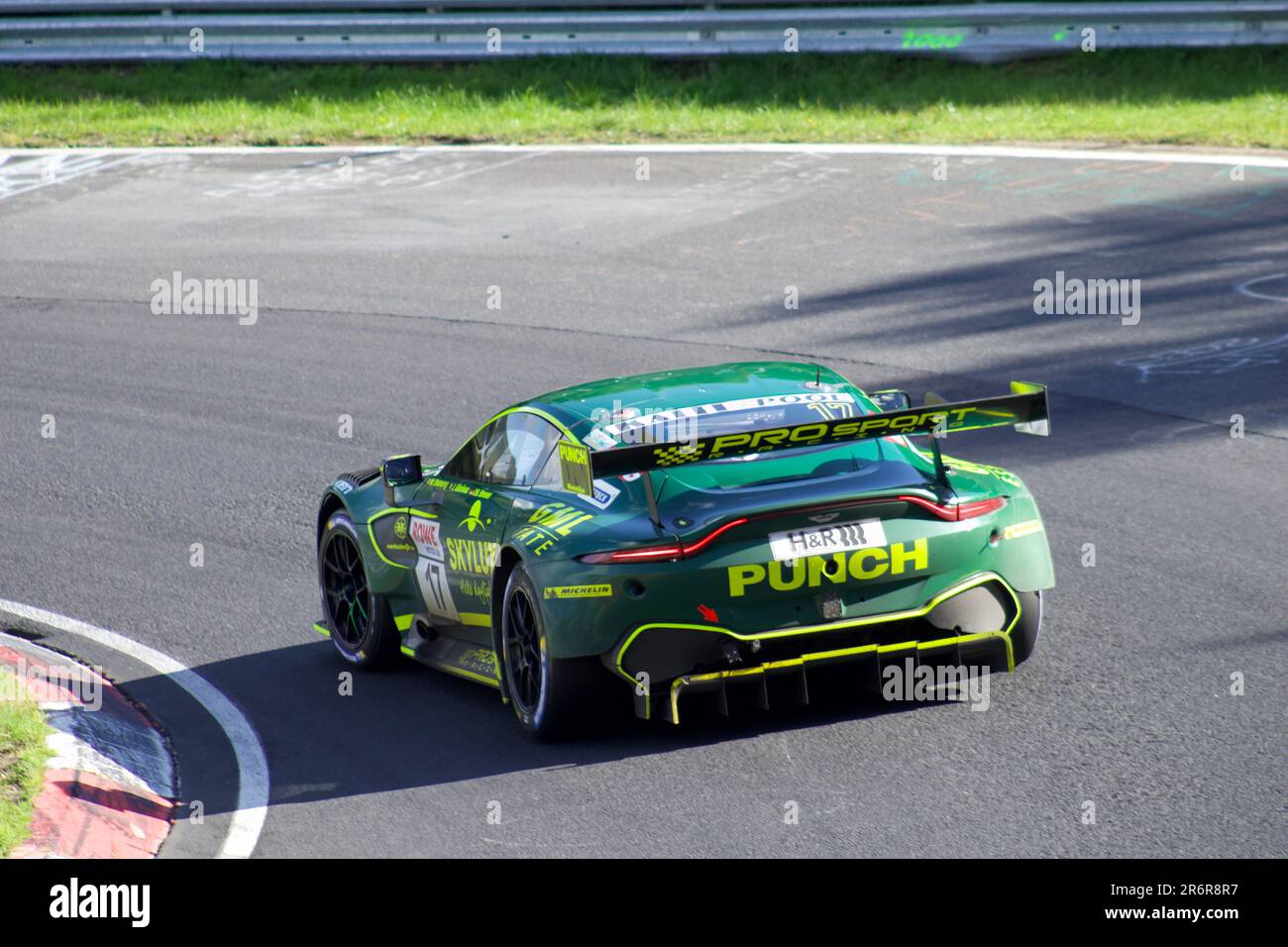 A green race car driving on a track, perfect for any motorsport or ...
