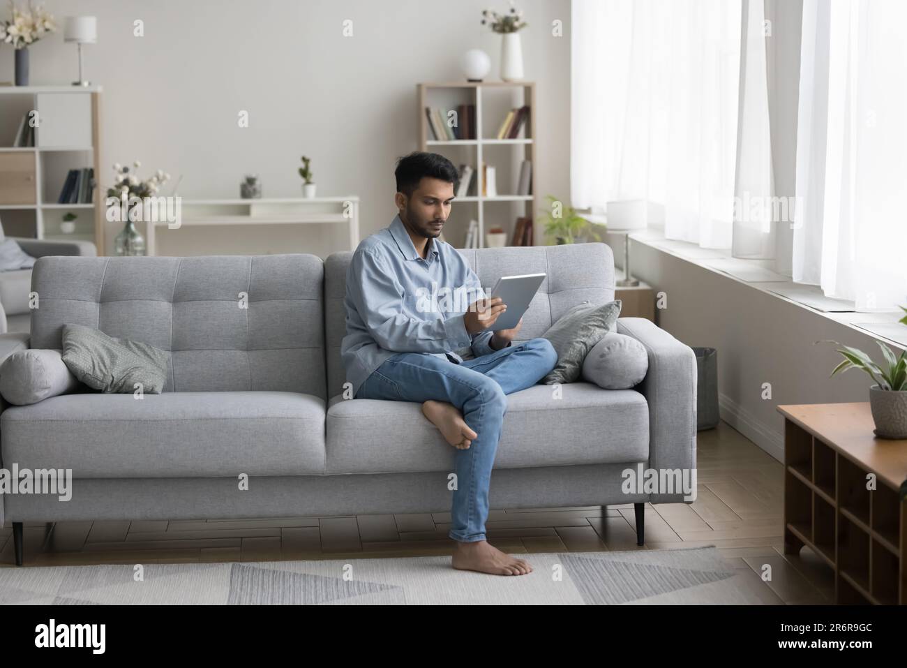 Focused Indian student guy using learning app on tablet Stock Photo - Alamy