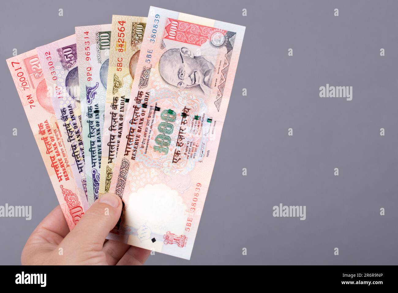 Old Indian money - rupee in the hand on a gray background Stock Photo ...