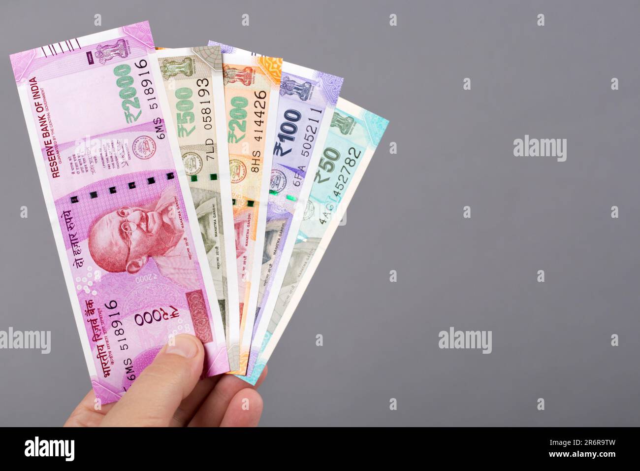 Indian money - rupee in the hand on a gray background Stock Photo - Alamy