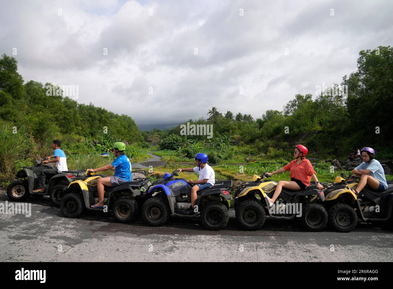 Tourists ride ATV's near Mayon Volcano, hidden in clouds, in Daraga ...