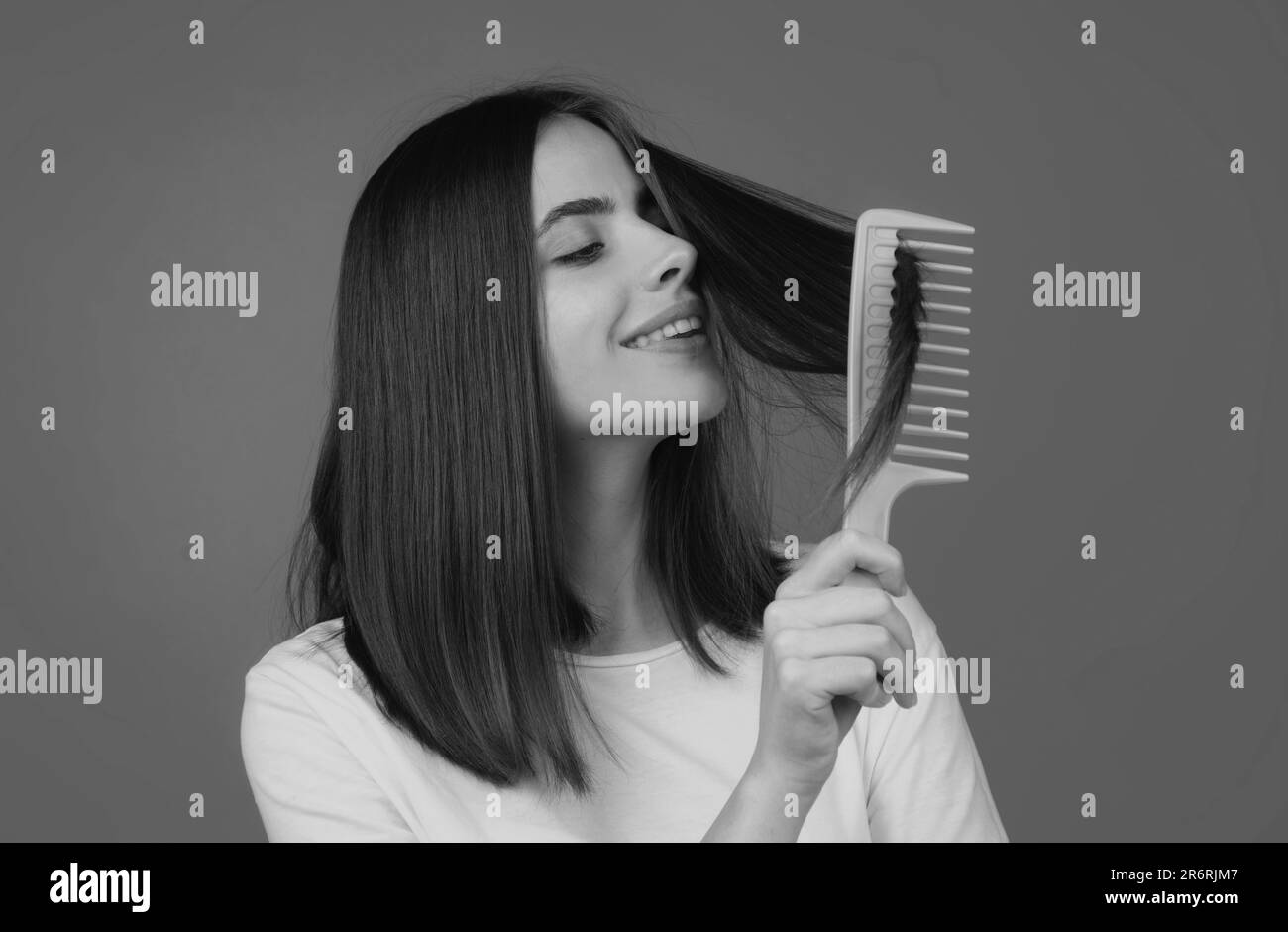 Attractive woman combing hair. Beautiful girl combs hair. Haircare ...